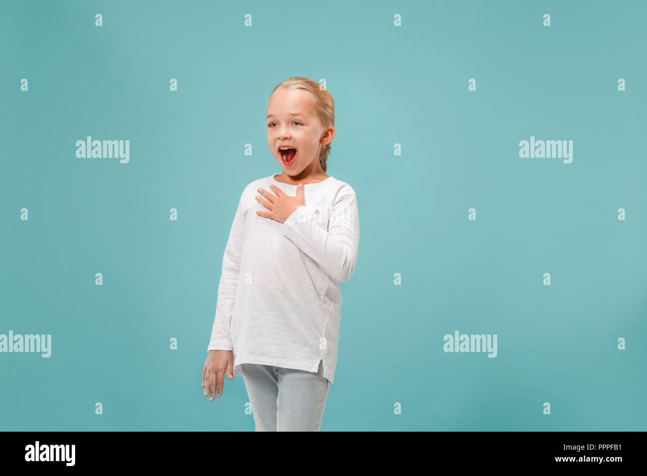 Happy young beautiful girl singing at studio isolated on blue ...