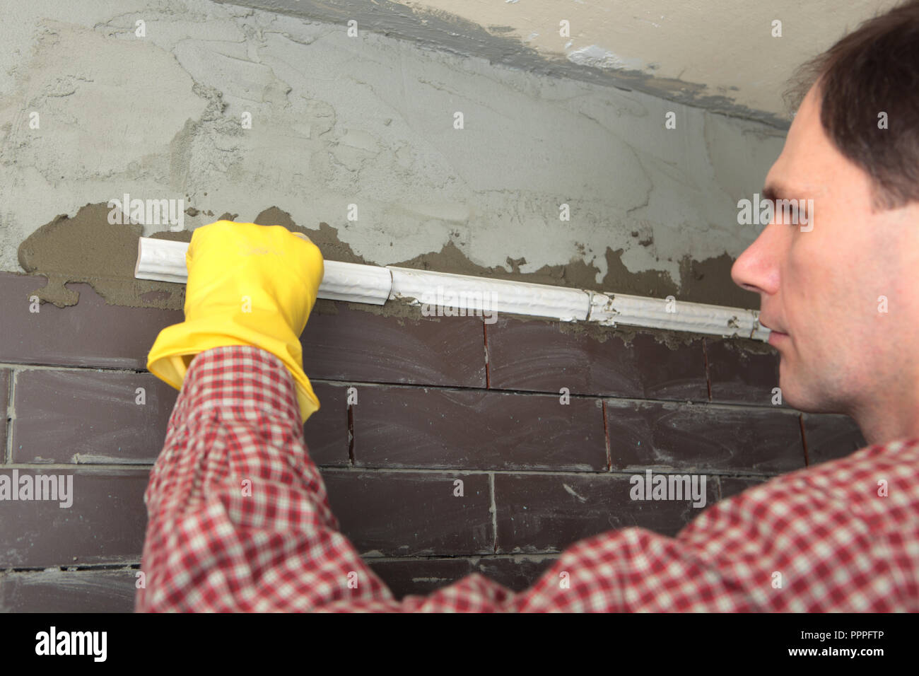 Contractor installing tiles on a wall Stock Photo - Alamy