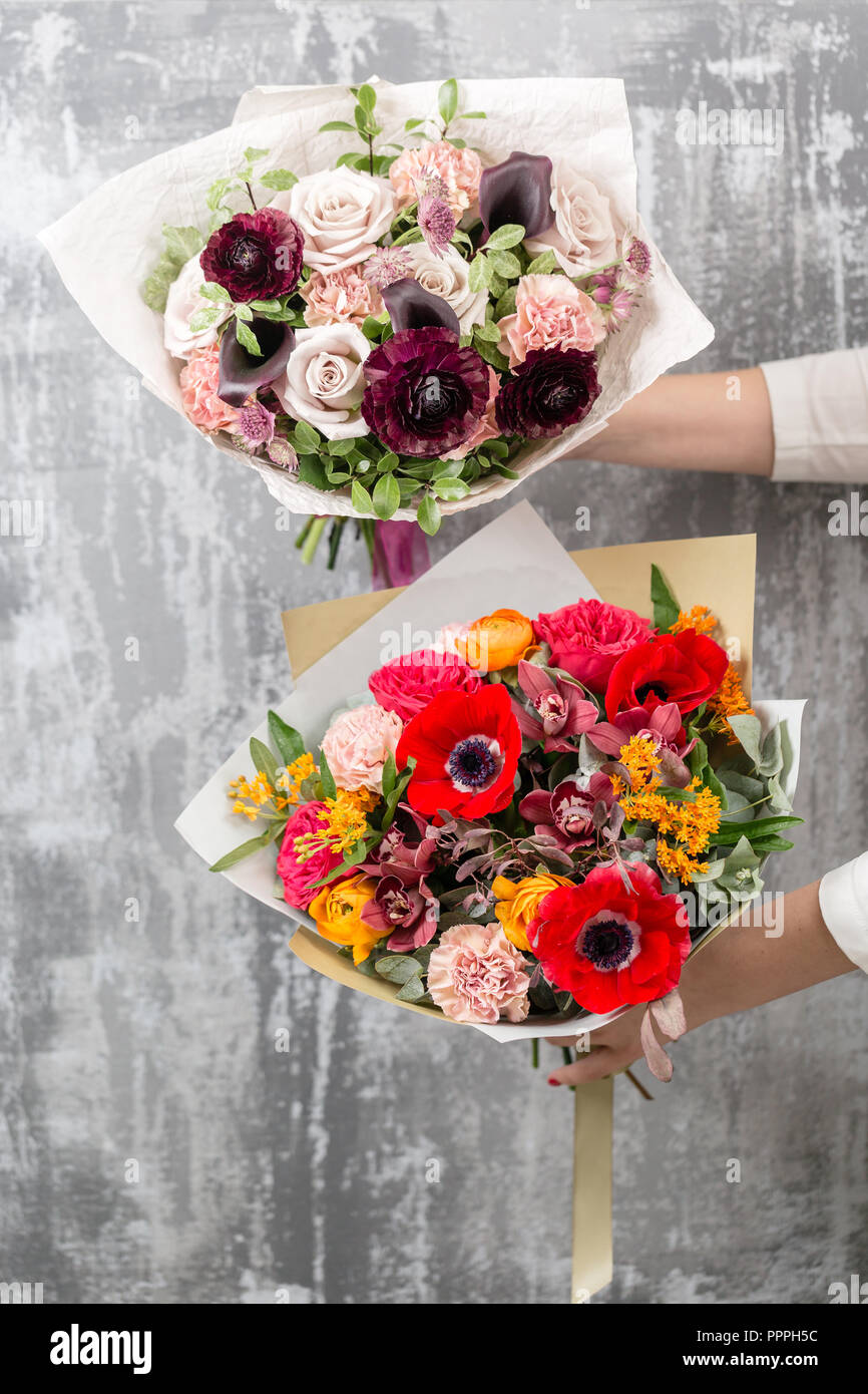 two beautiful bouquet of mixed flowers in woman hand. the work of the ...