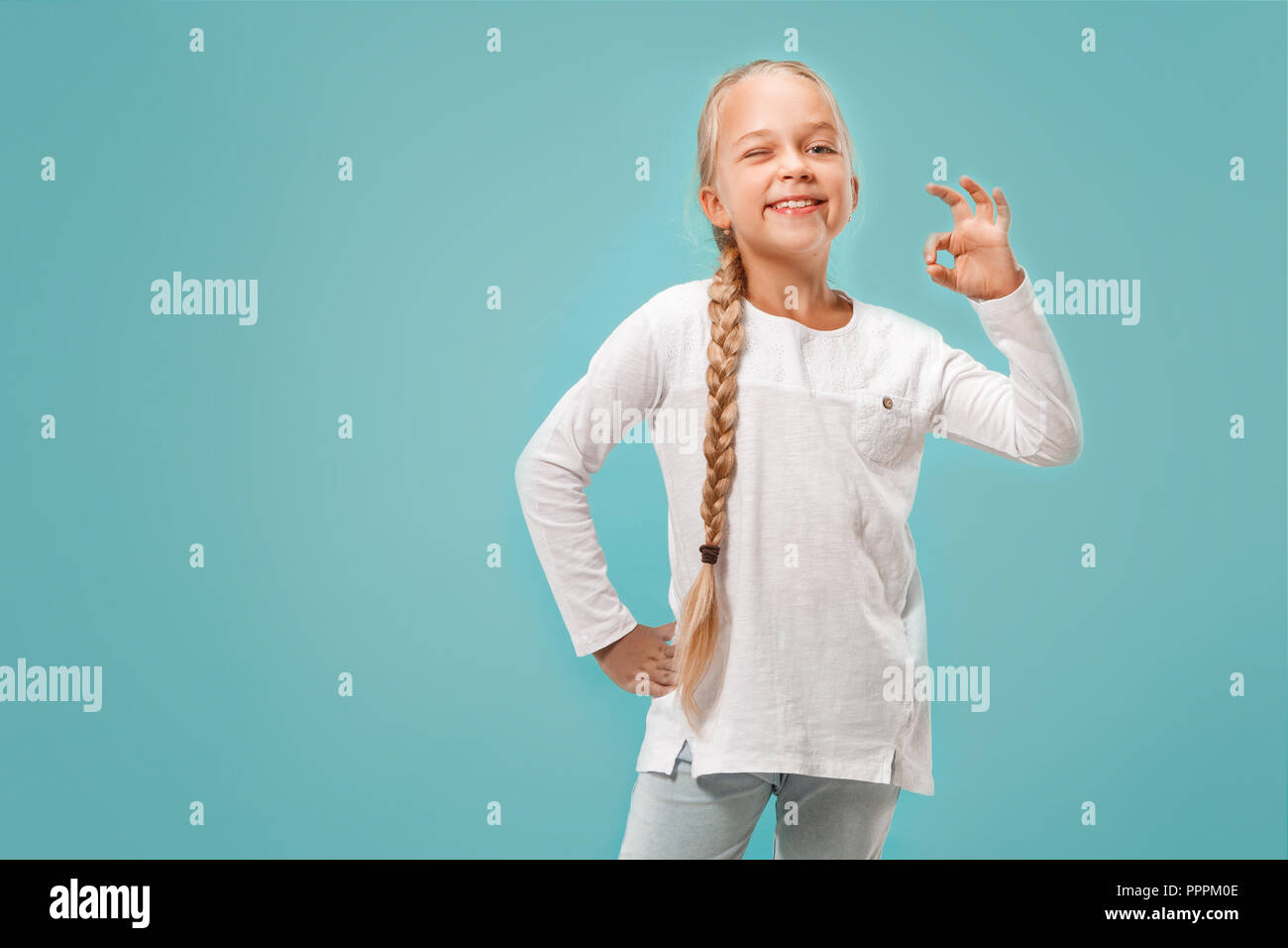 Happy teen girl standing, smiling isolated on trendy blue studio ...