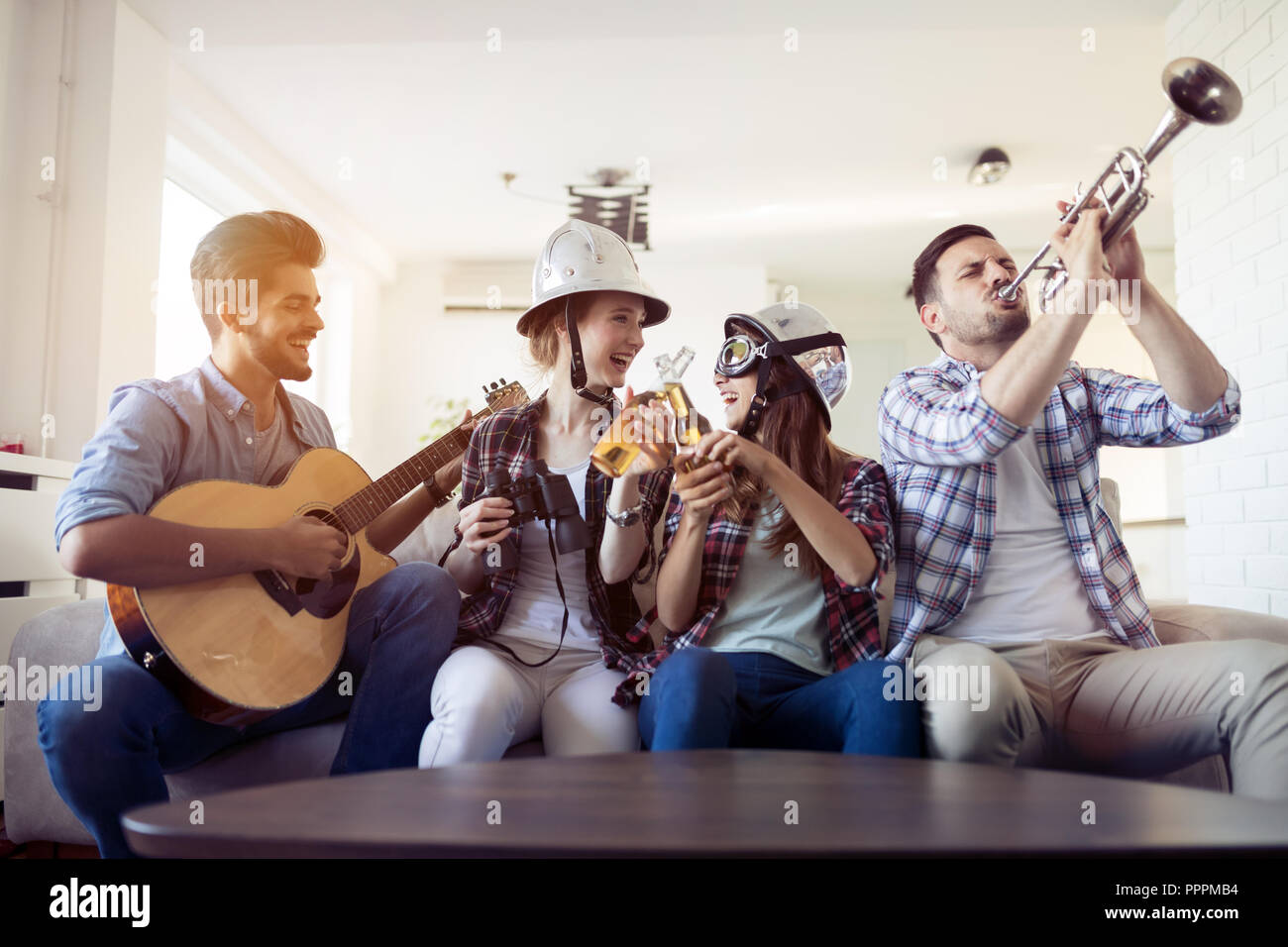 Cheerful friends having party together and playing instruments Stock ...