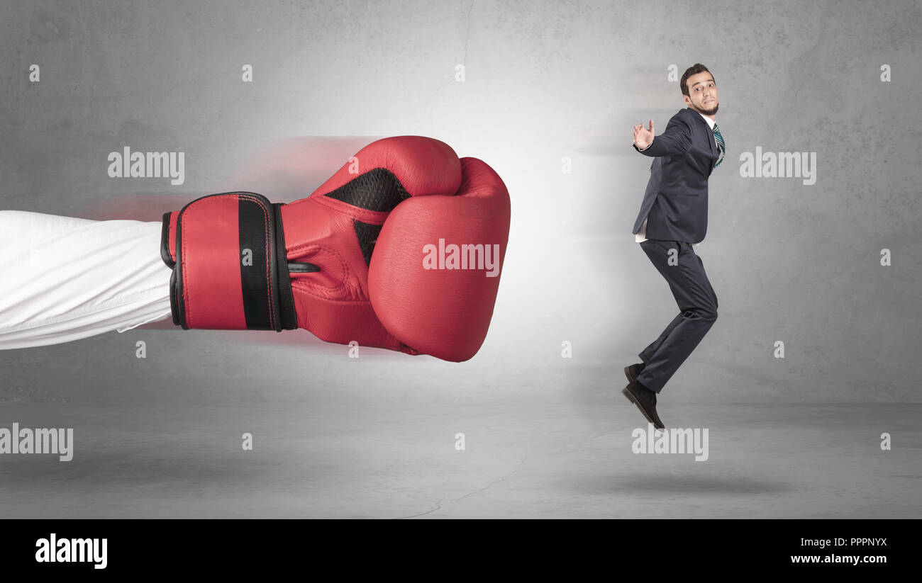 Businessman gets a hit from a giant hand with boxing gloves Stock Photo ...