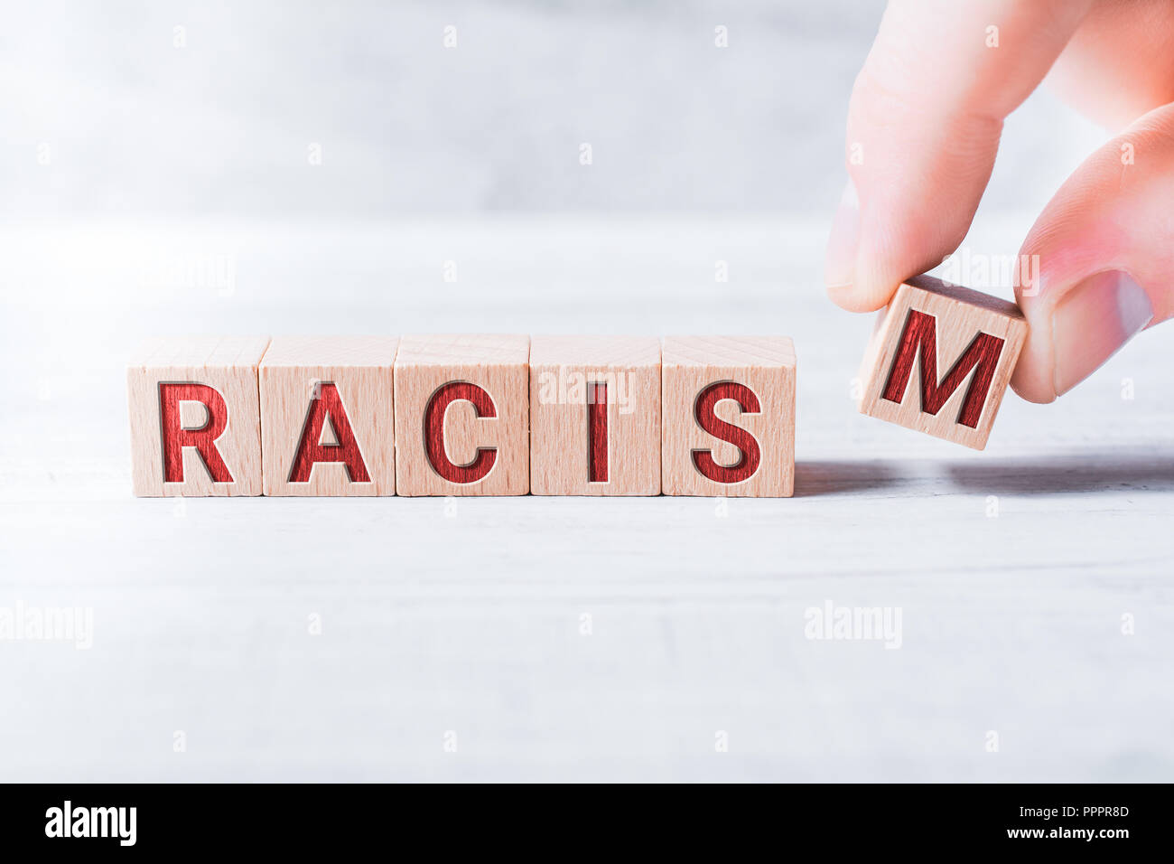 The Word Racism Formed By Wooden Blocks And Arranged By Male Fingers On ...