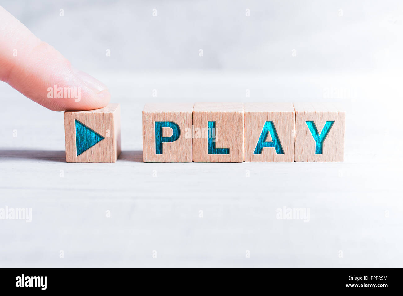 The Word PLAY Formed By Wooden Blocks And Arranged By A Male Finger On ...