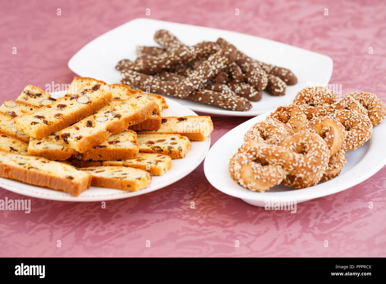 Different crackers in plates on pink cloth background Stock Photo - Alamy