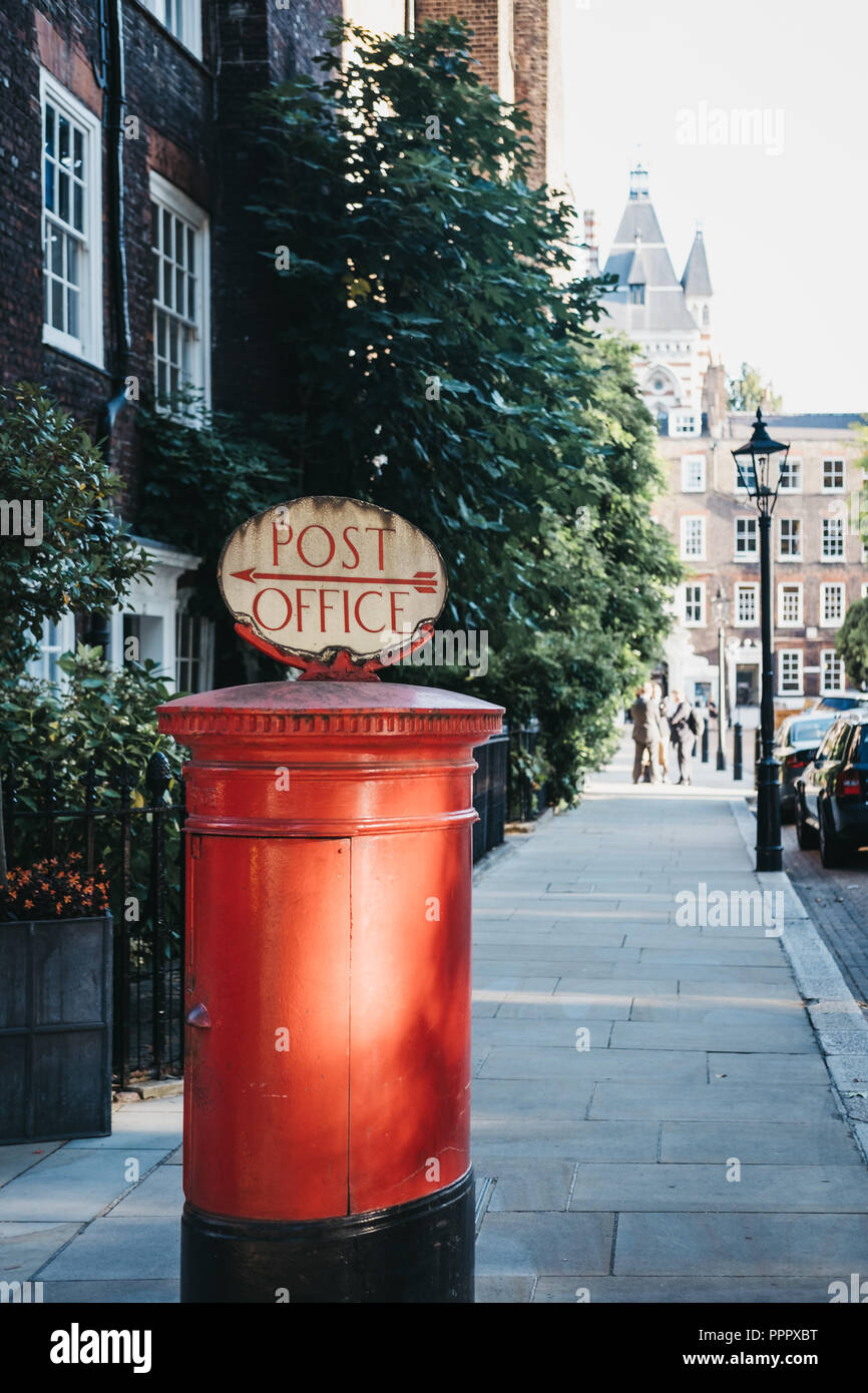 Red post box with a retro Post Office directional sign on top in London ...