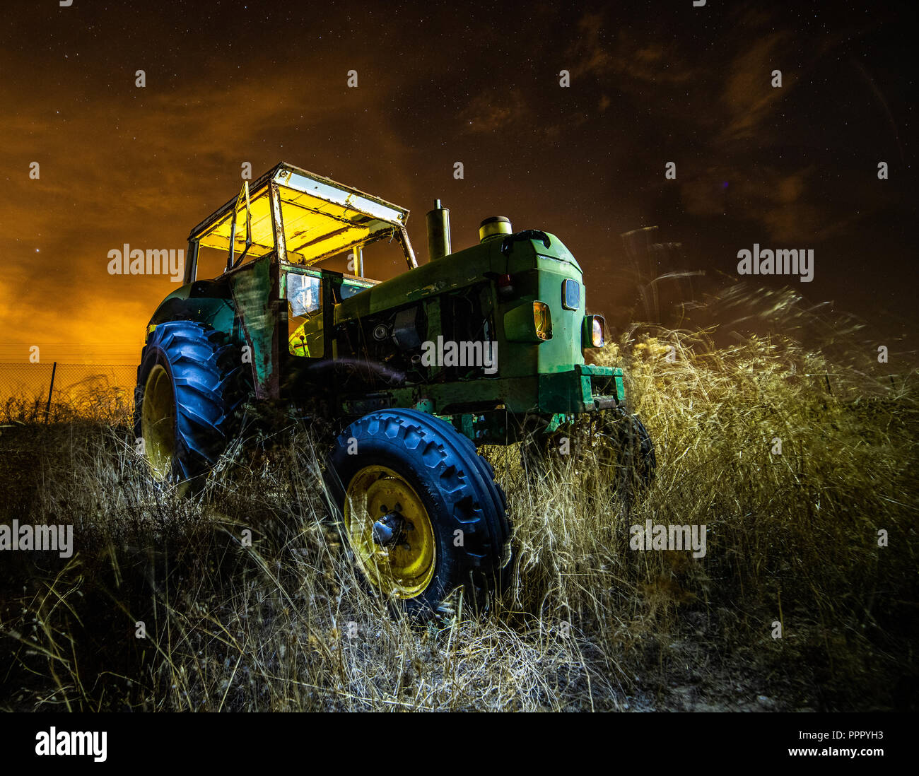 Agricultural tractor abandoned and illuminated with flashlights Stock ...