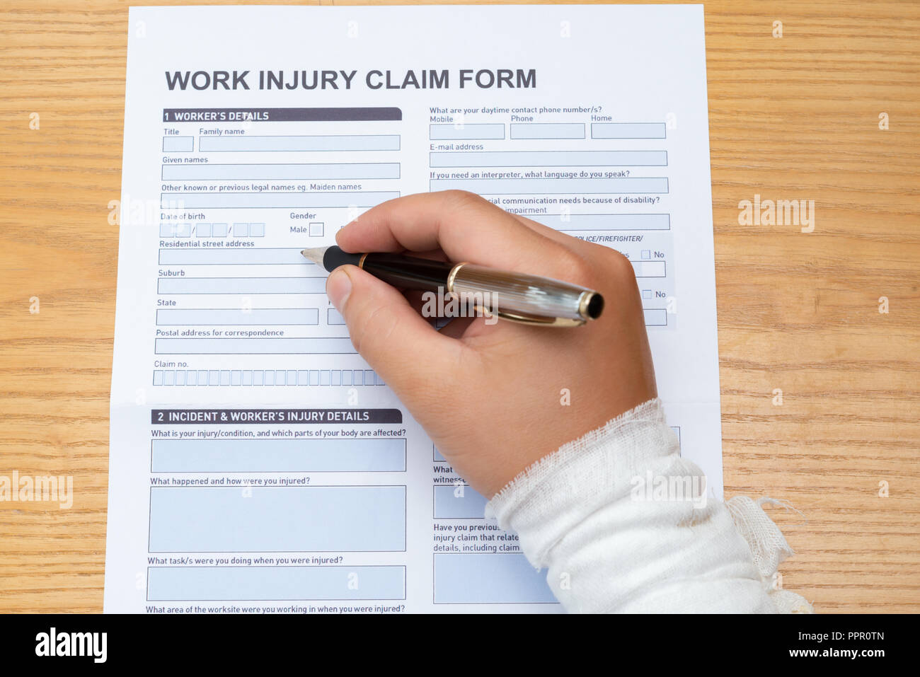 filling up a work injury claim form with a wrapped hand medical and ...