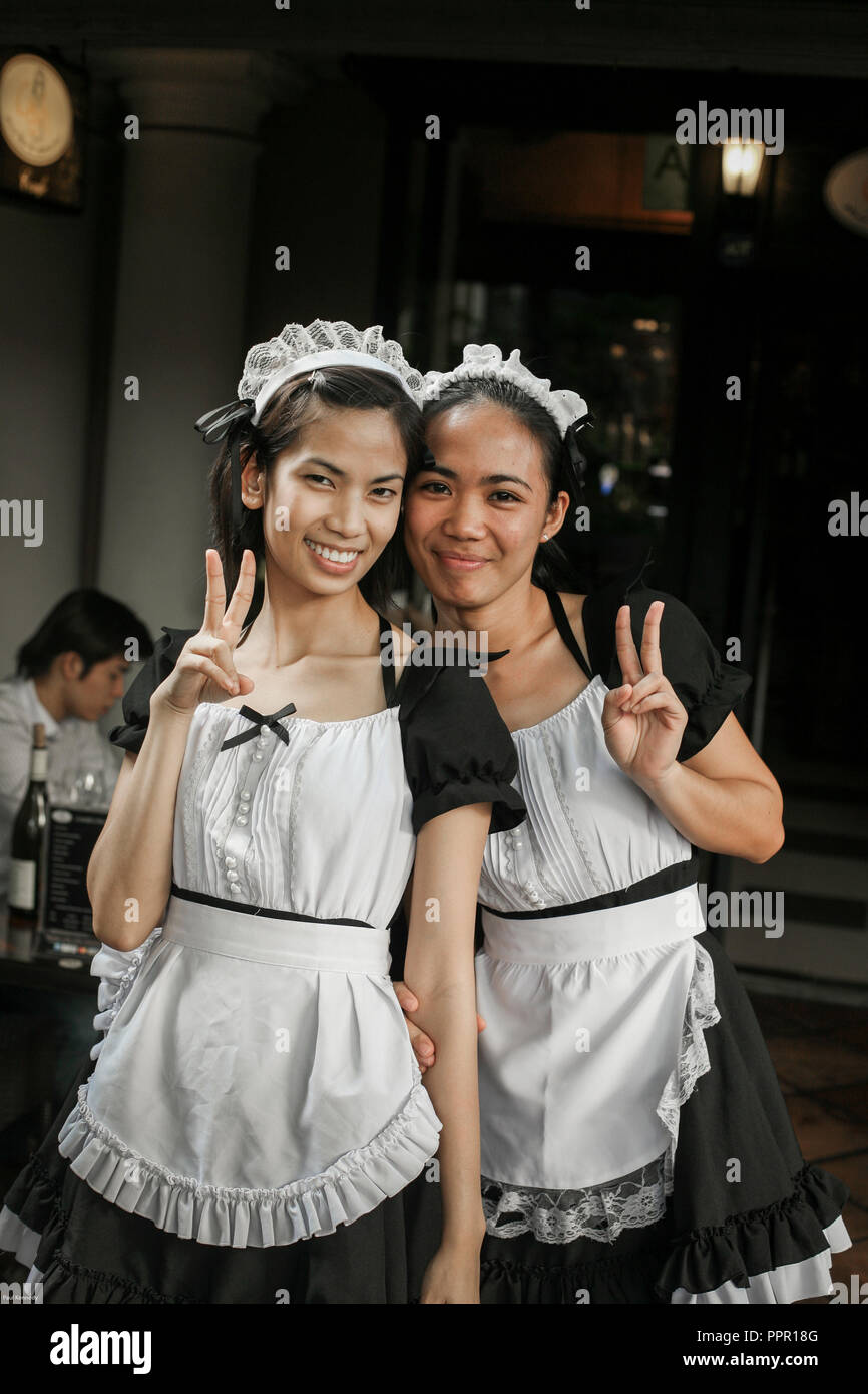 Two friendly waitresses in uniform pose for a photo in a Singapore ...