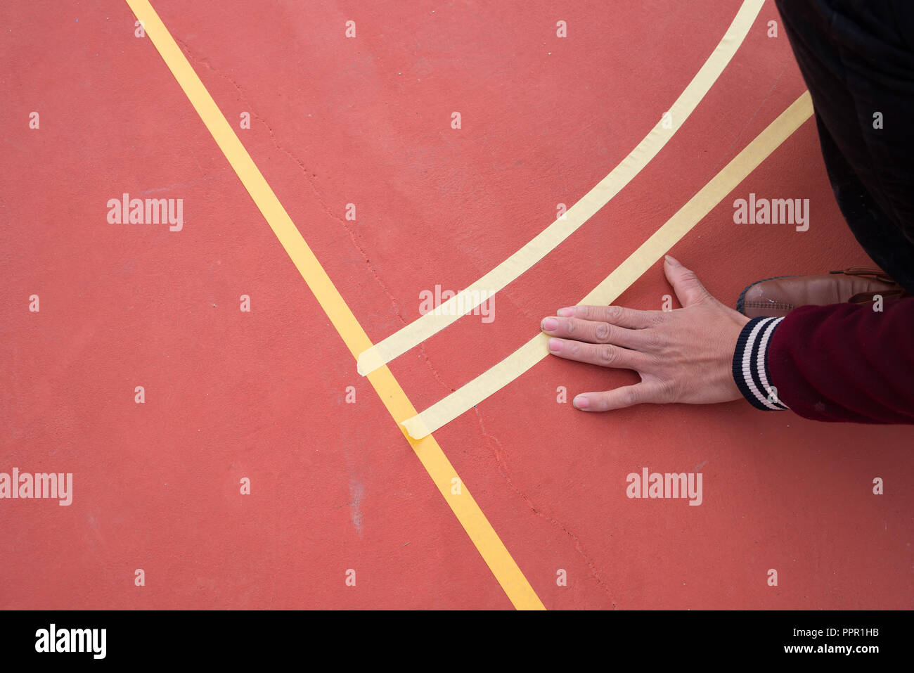 workers taping and marking the sideline on the floor for an outdoor ...