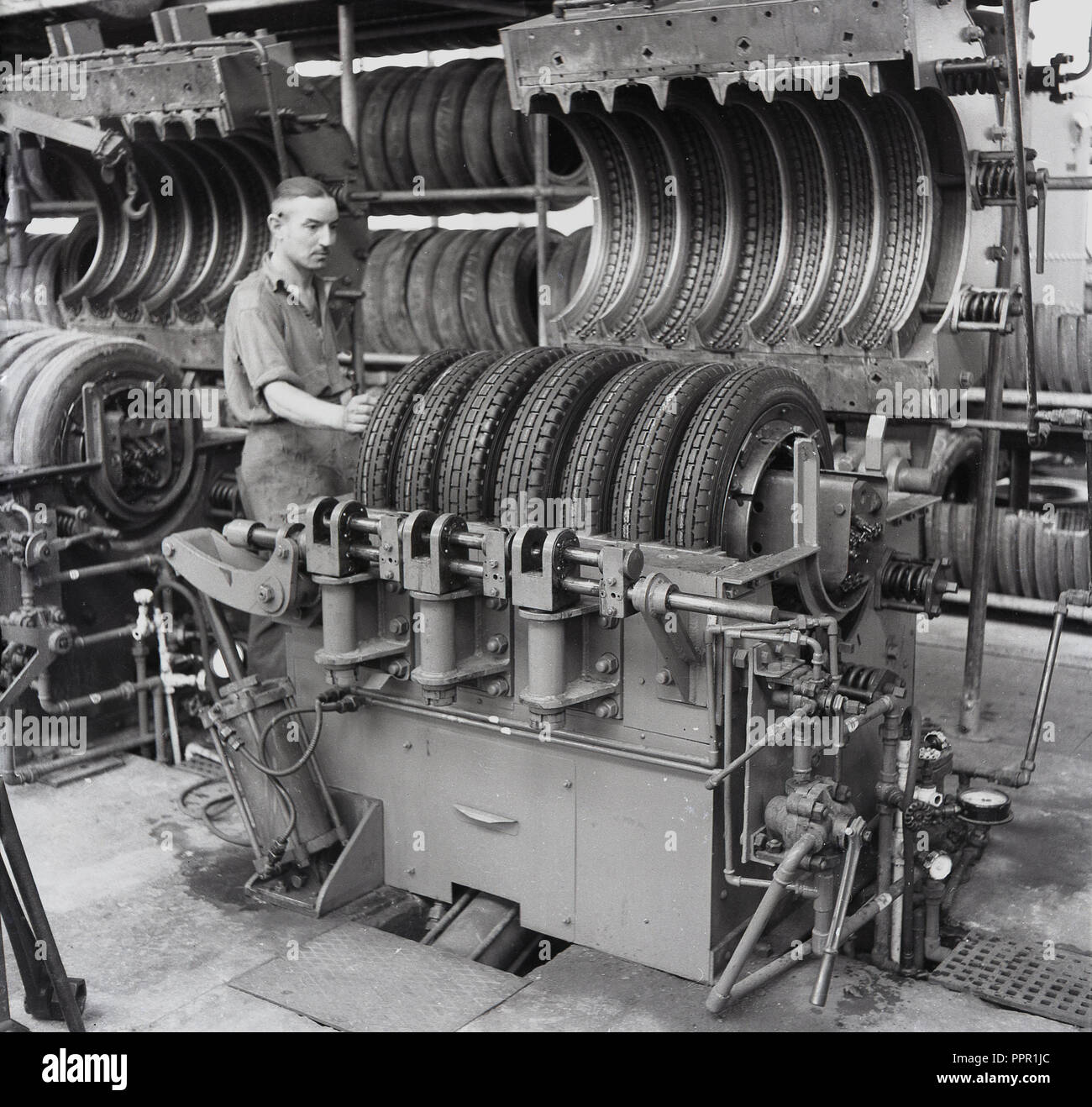 1950s, historical, a worker using a moulding machine to produce rubber ...