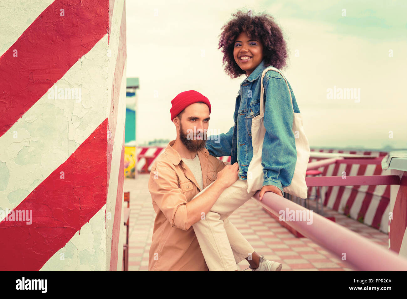 Handsome man looking confident while his girlfriend sitting on the hand ...