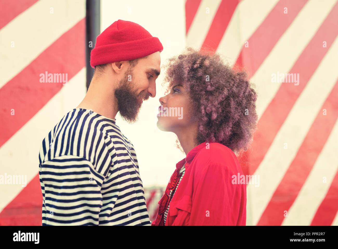 Beautiful young people standing close to each other and expecting the ...