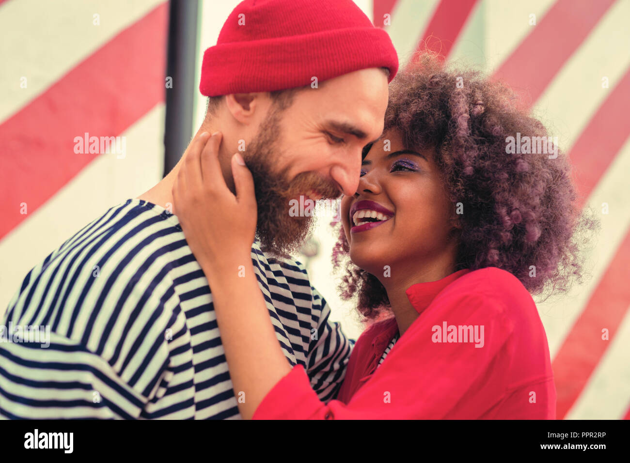 Cute young couple laughing while standing and hugging Stock Photo - Alamy