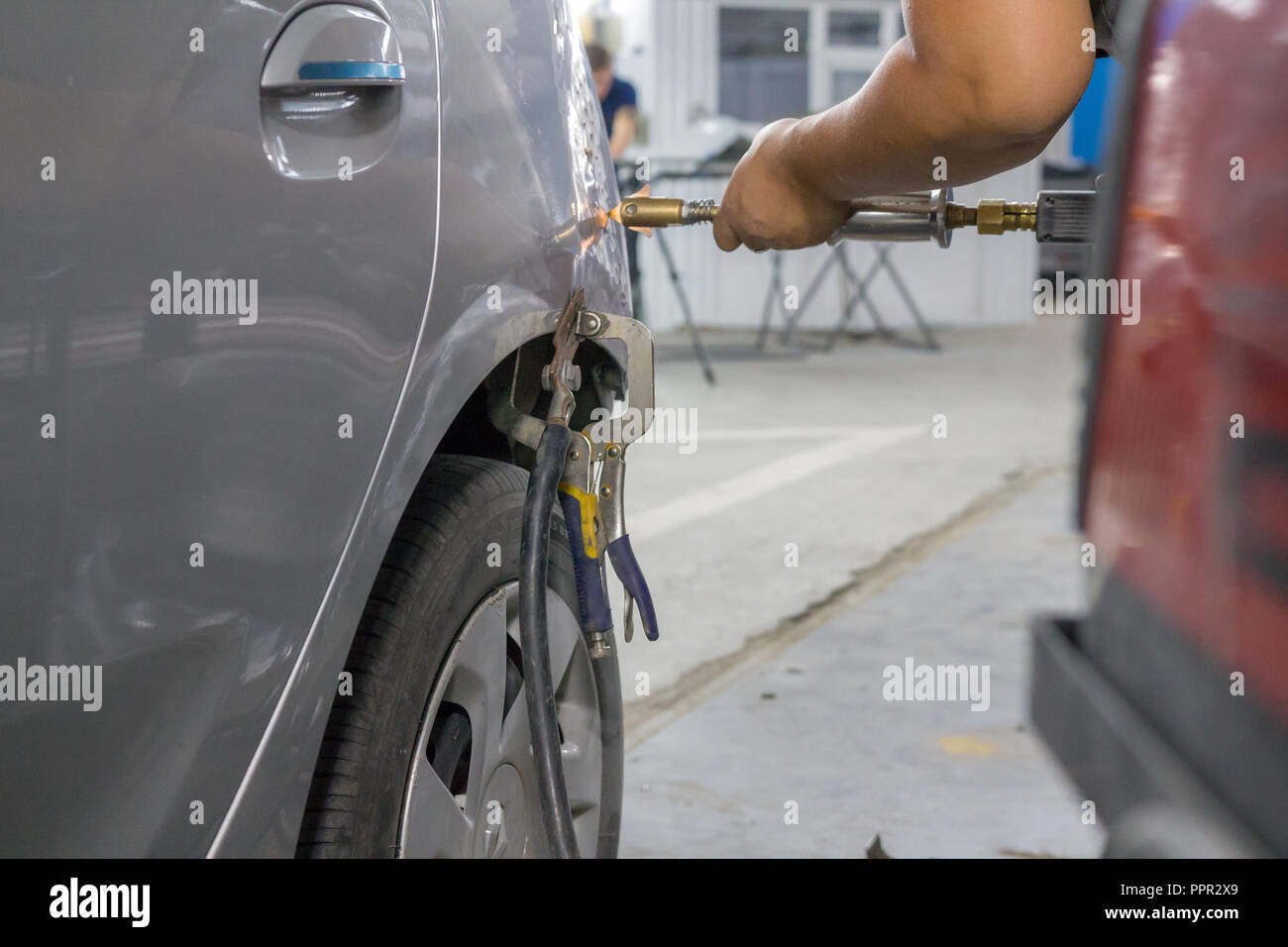Mechanic's hands fix dents on the car's body with a special vacuum ...