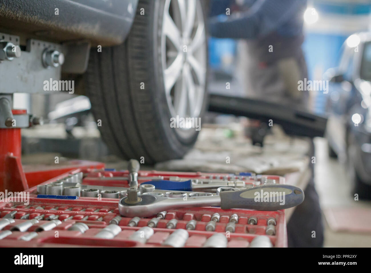 Mechanic tools lie next to the car's wheel on repair Stock Photo - Alamy