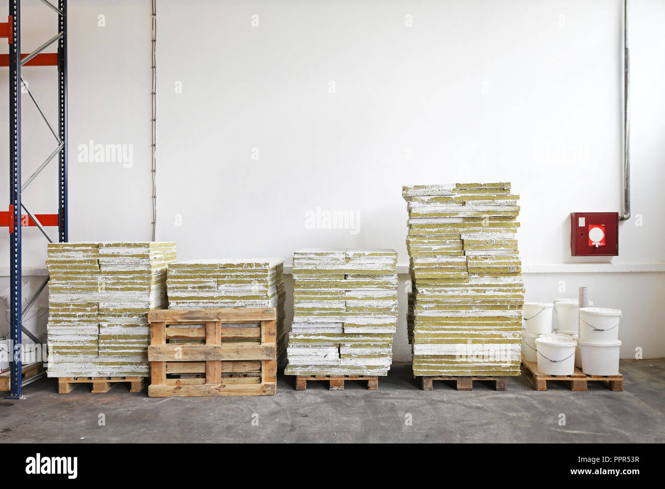 Pallets with construction material in storage room Stock Photo - Alamy