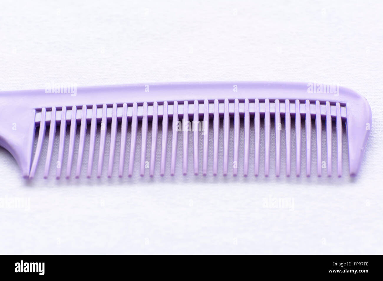 The purple hair comb on white background Stock Photo - Alamy