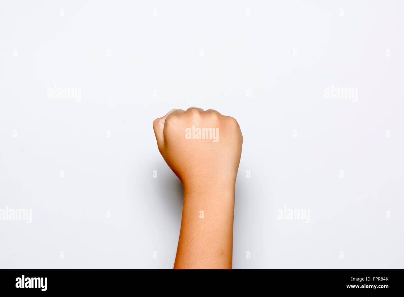 Boy raising fist hand on white backgrounds Stock Photo - Alamy