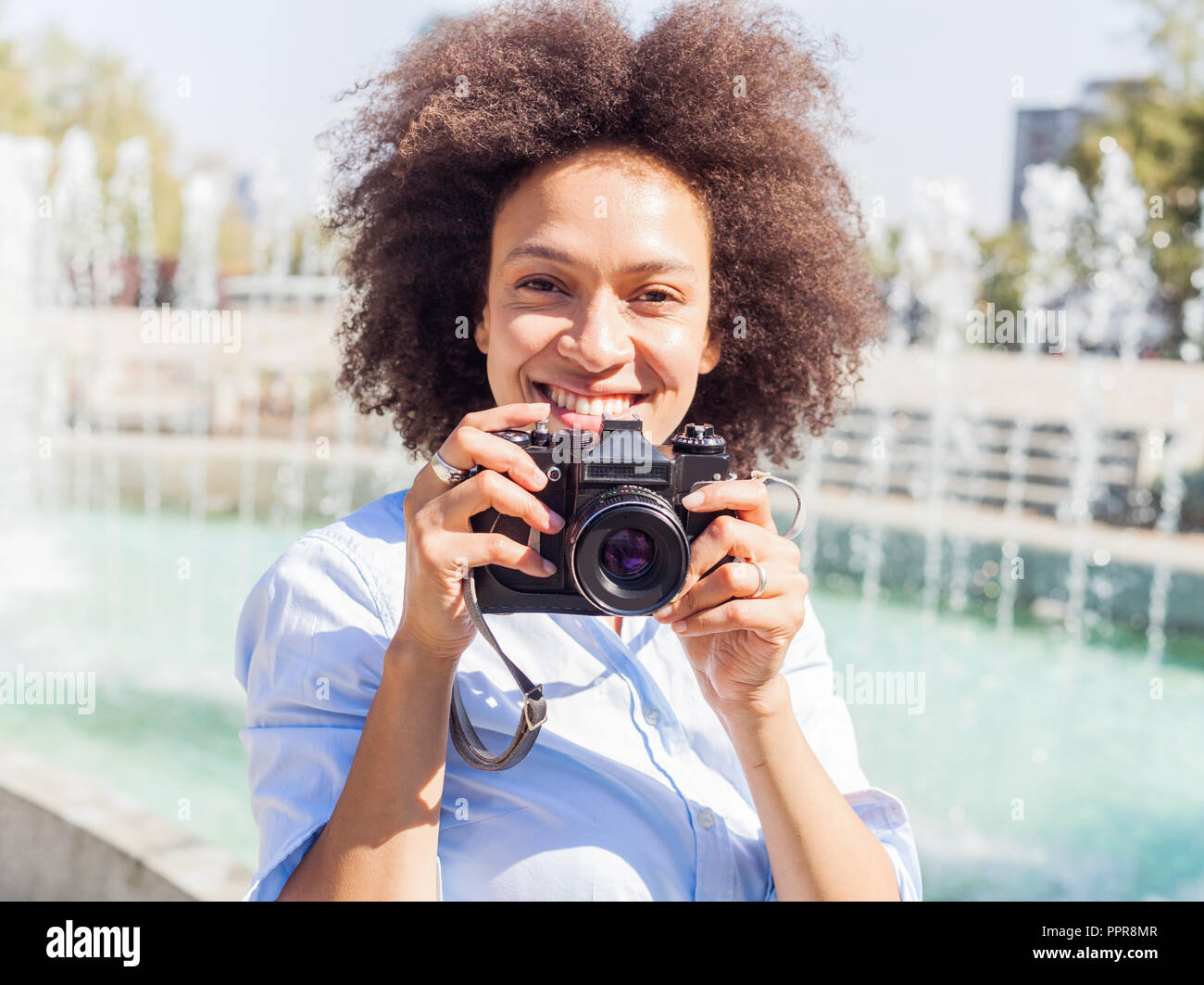 Portrait of charming black woman with retro camera, female photographer ...