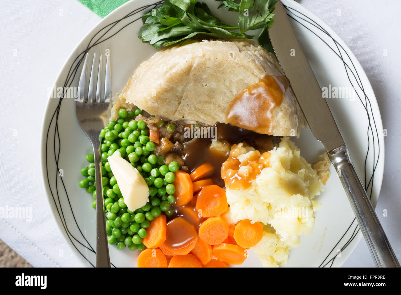 English pub/restaurant dish of steamed beef pudding served with garden ...