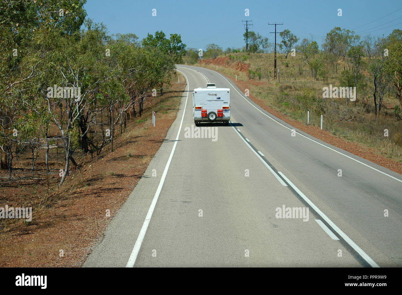 CARAVAN TRAVELLING ON AN OUTBACK ROAD IN THE NORTHERN TERRITORY ...