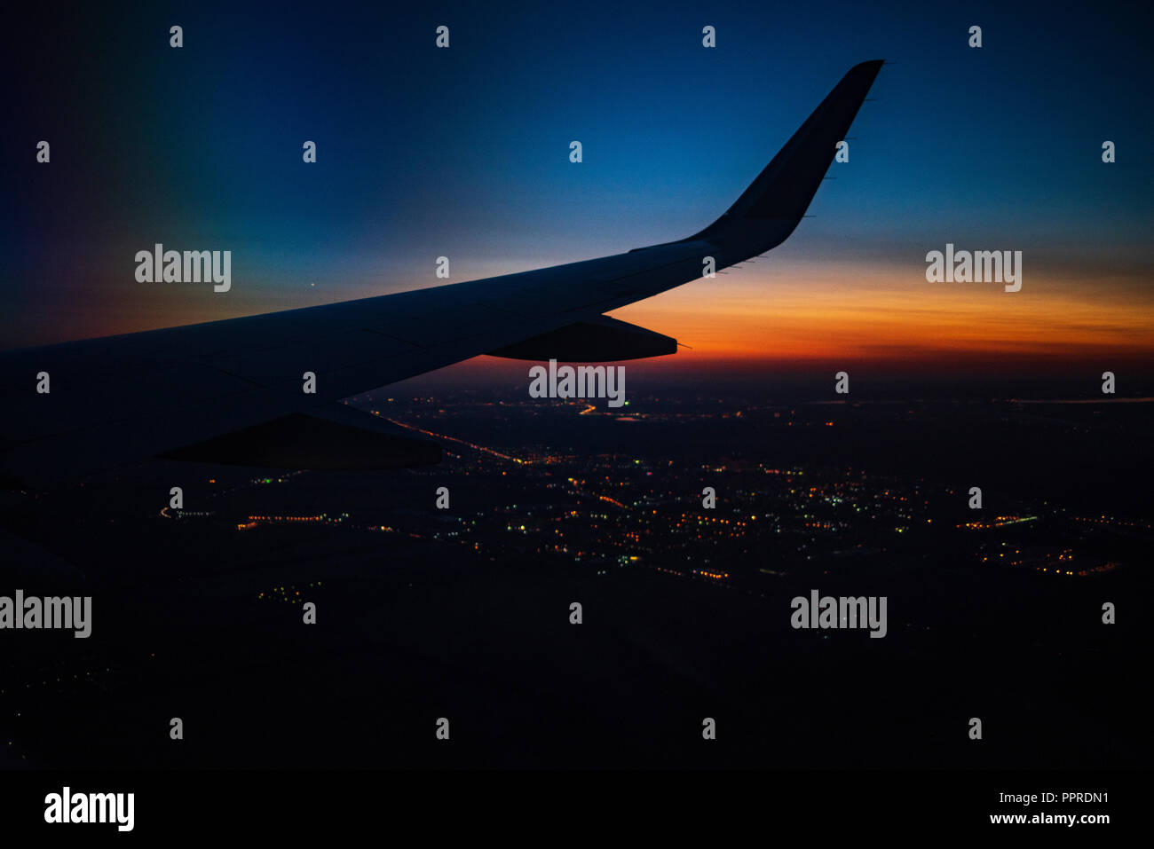 Night view from a window in an airplane, wing of an airplane. A sunset ...