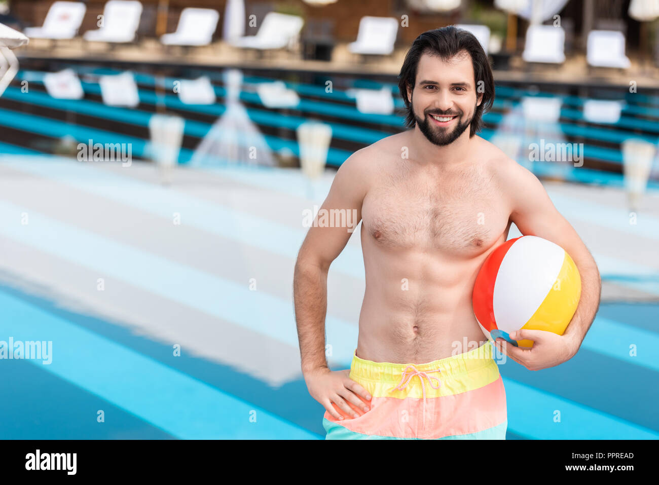 bearded man with inflatable ball standing at swimming pool Stock Photo ...