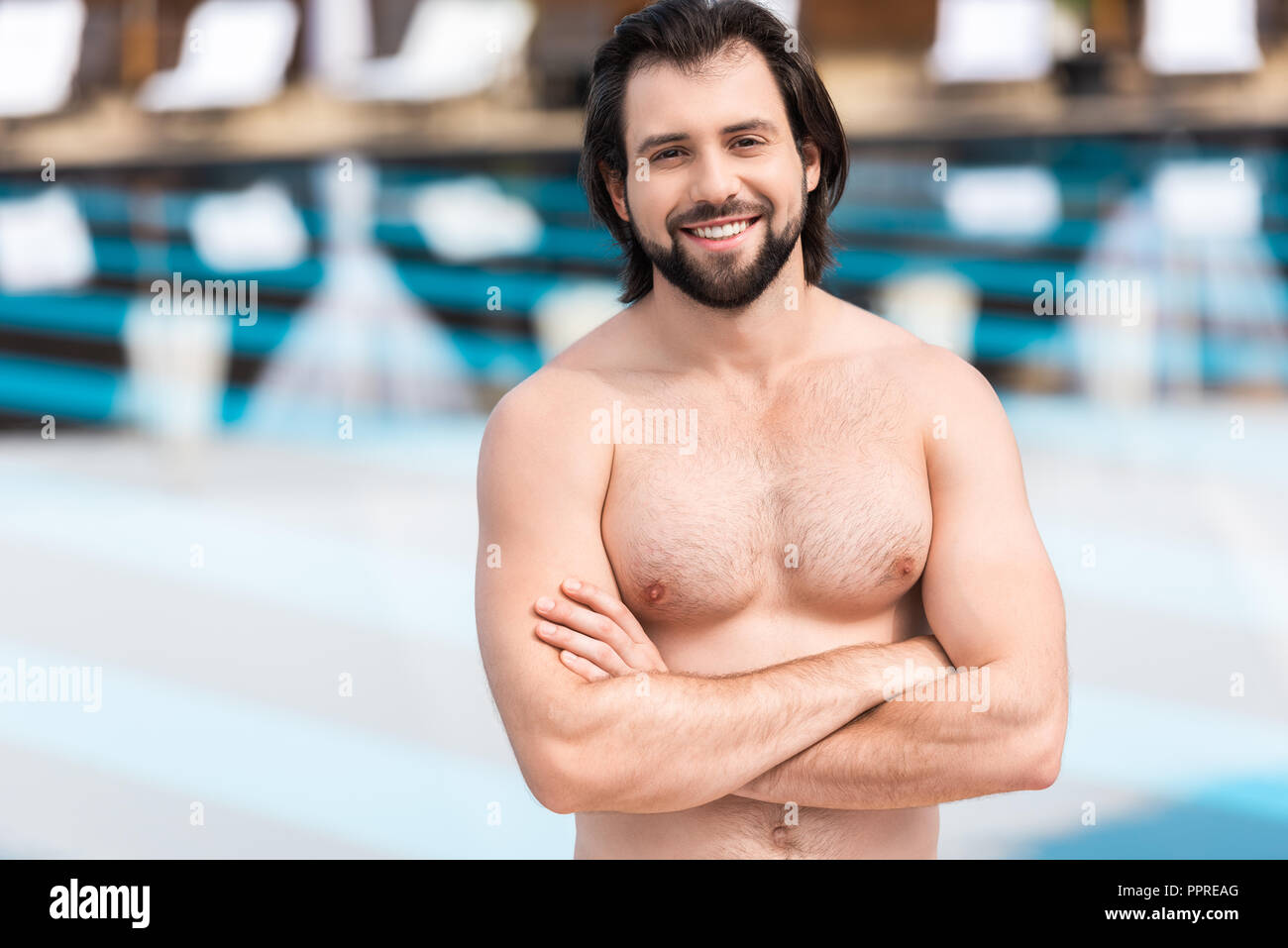bearded man standing with crossed arms at swimming pool Stock Photo - Alamy
