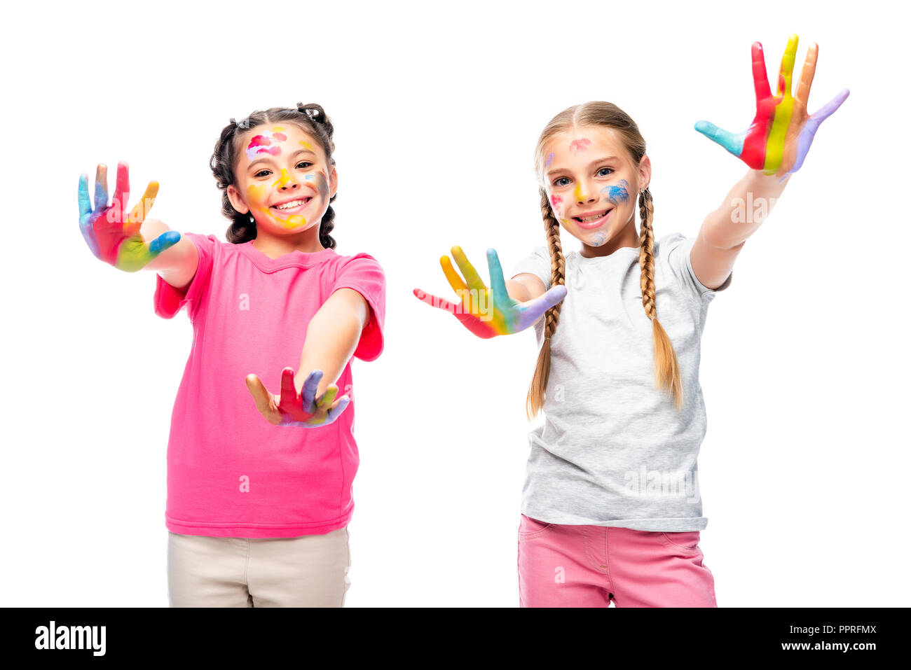 schoolchildren showing painted colorful hands and looking at camera ...