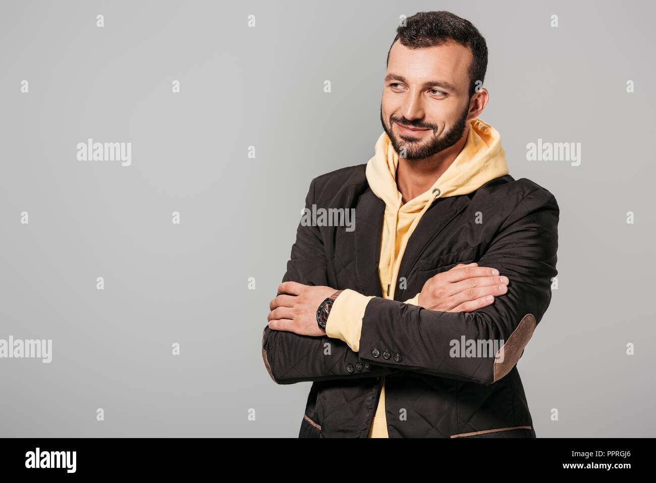 smiling male model posing with crossed arms isolated on grey background ...