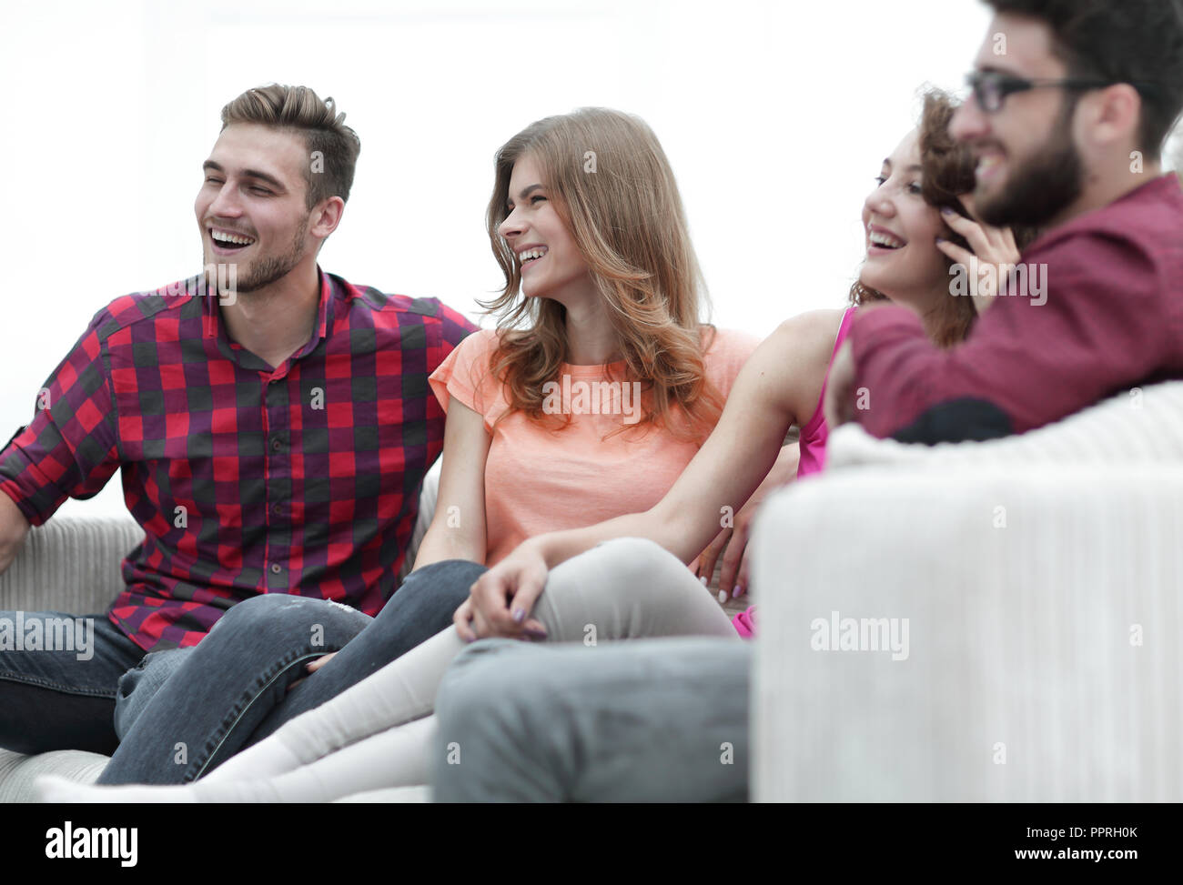 group of cheerful friends sitting on the couch Stock Photo - Alamy