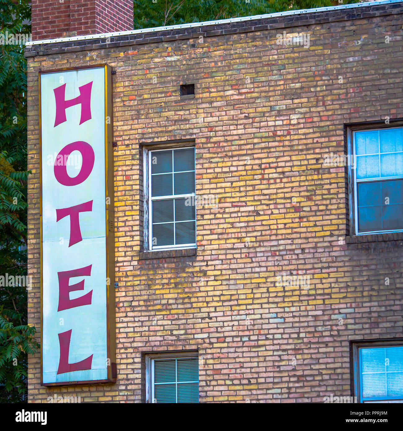 Hotel sign beside the windows of a brick building Stock Photo - Alamy