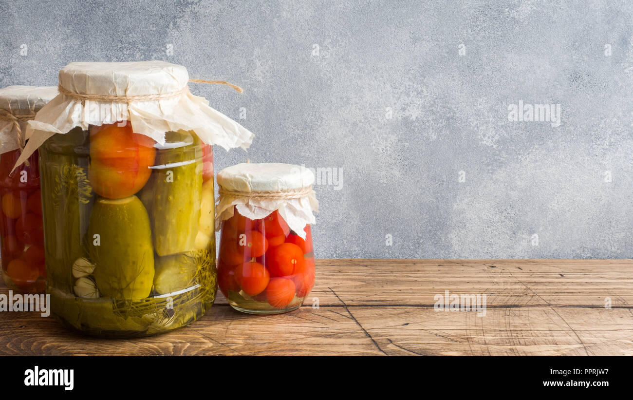 Homemade canned vegetables in cans. Pickled tomatoes and cucumbers in a ...