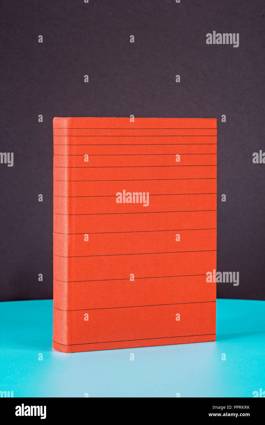 Red striped book on the green metal table. Black background Stock Photo ...