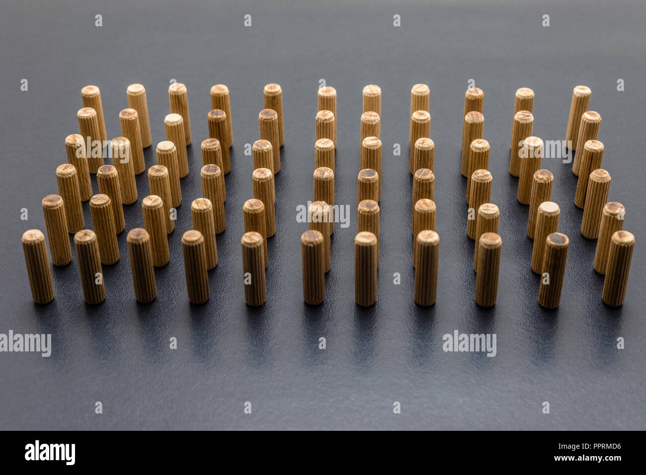 A lot of wooden pegs standing vertically on a black background Stock ...