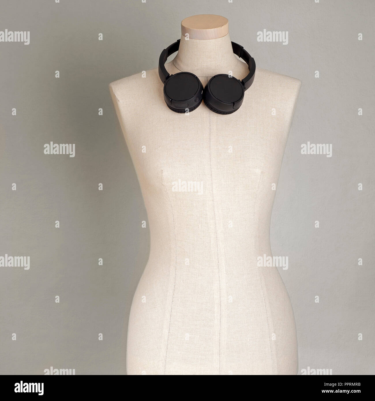 Female mannequin with headphones around neck. Grey background. Front ...