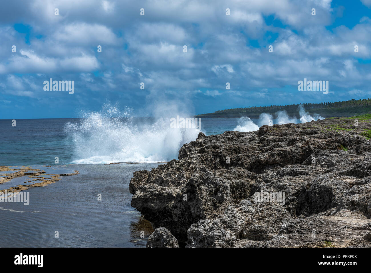 A row of geysers shoots toward the sky as the ocean tide rolls in and ...