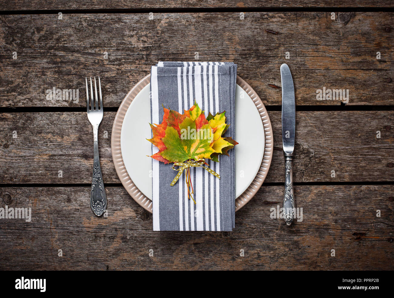 Autumn table setting with colorful leaves Stock Photo - Alamy