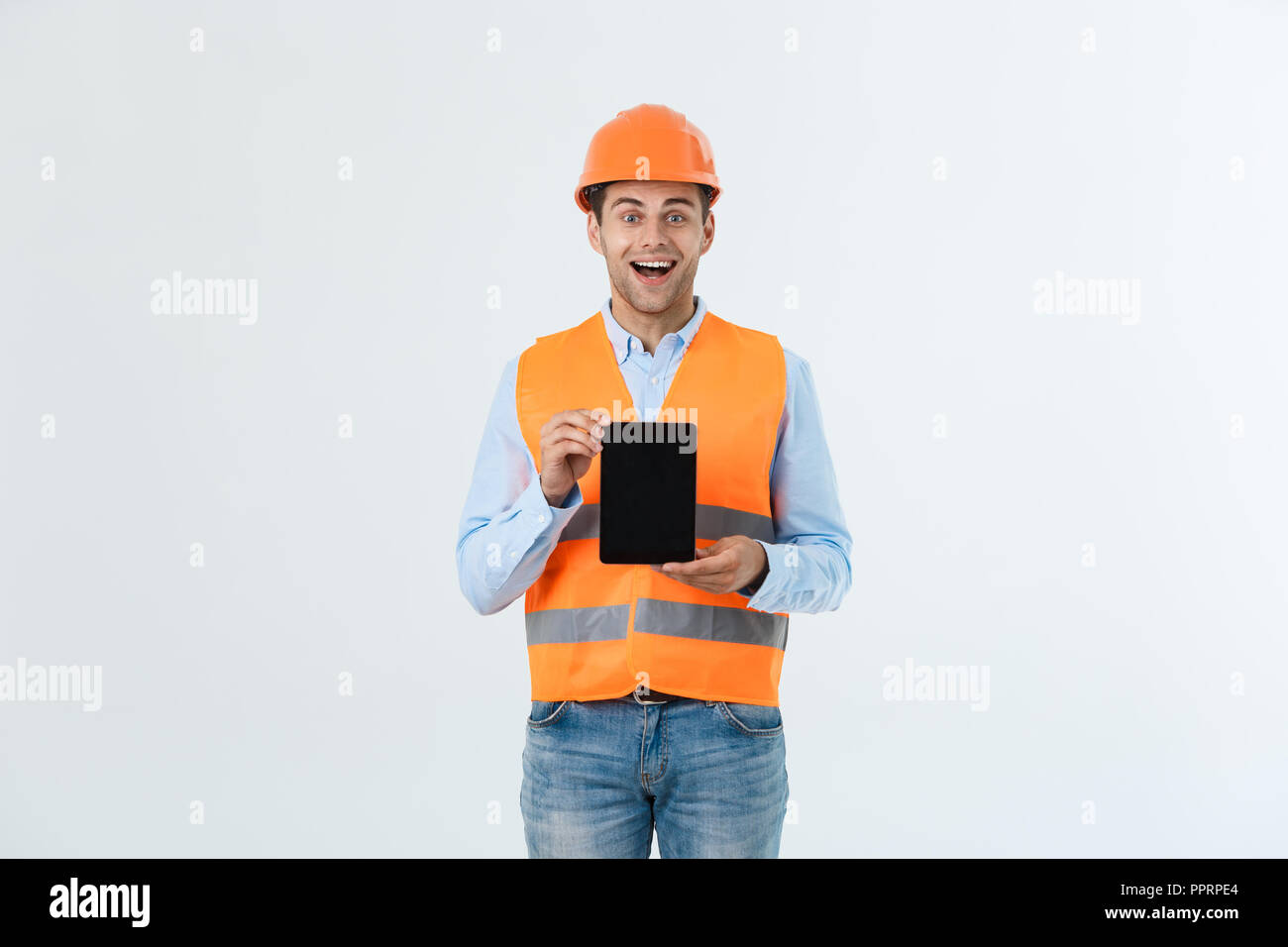 Shocked male engineer showing tablet screen, looks with opened mouth as ...