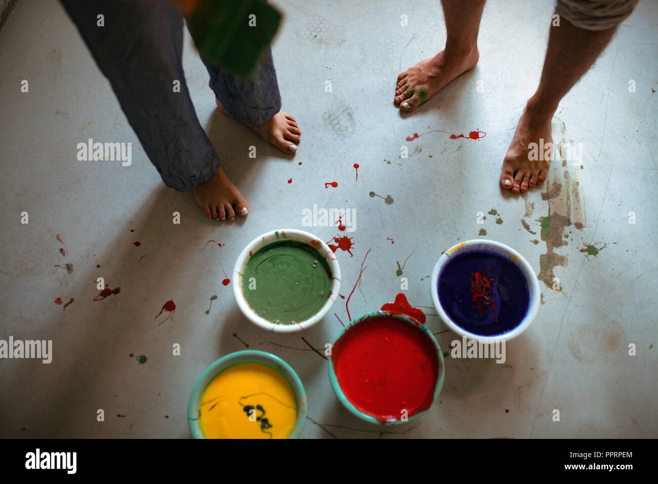 Female and male legs on background of buckets with red, green, yellow ...