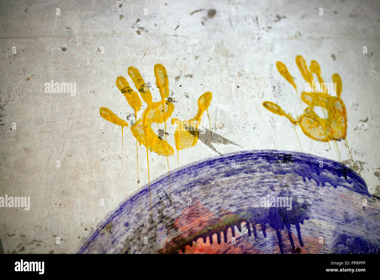 Blue drawing and two yellow palm prints on wall. Closeup Stock Photo ...