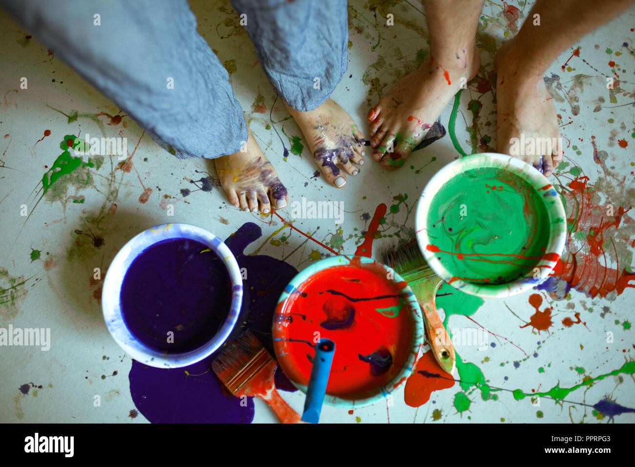 Female and male legs on background of paint stains and buckets with red ...