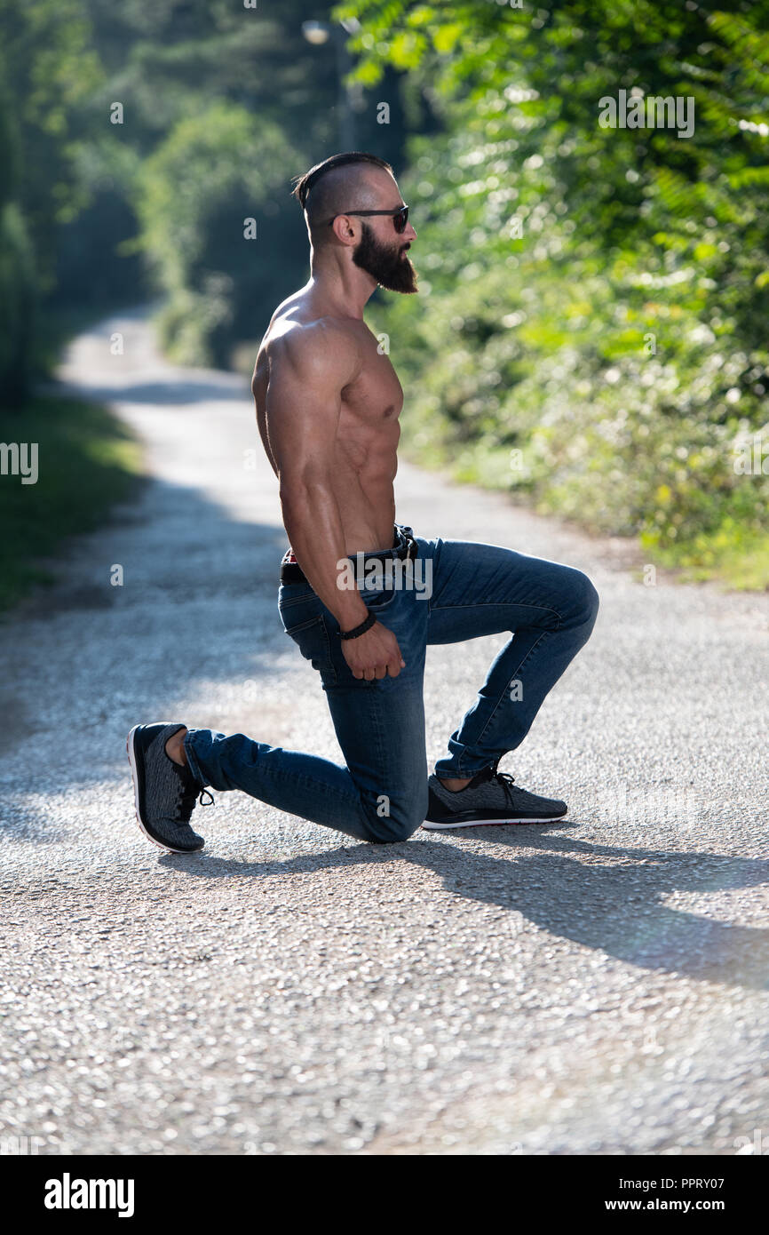 Muscular man flexing kneeling hi-res stock photography and images - Alamy