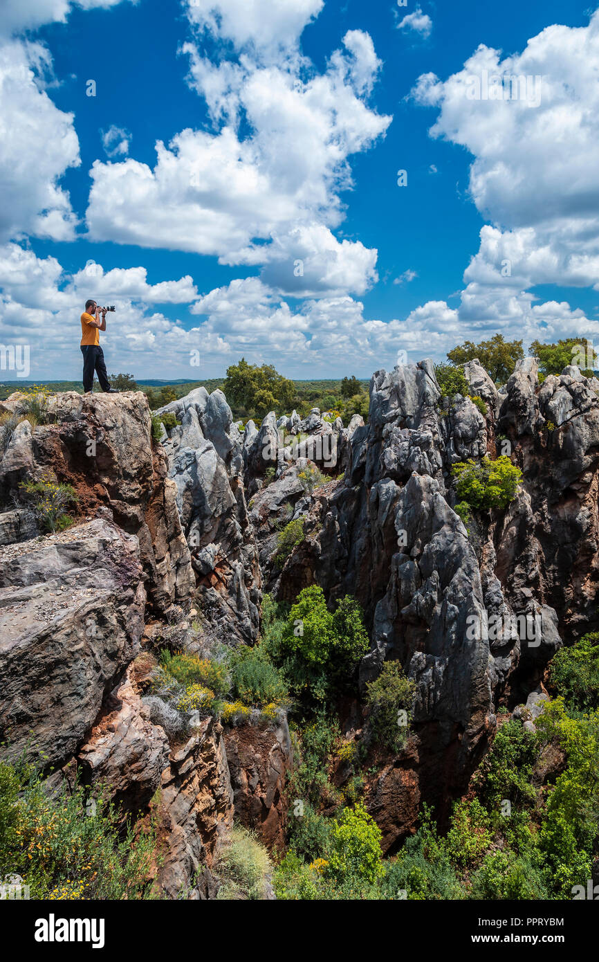 Side view of adult man with photo camera standing on cliff edge and ...