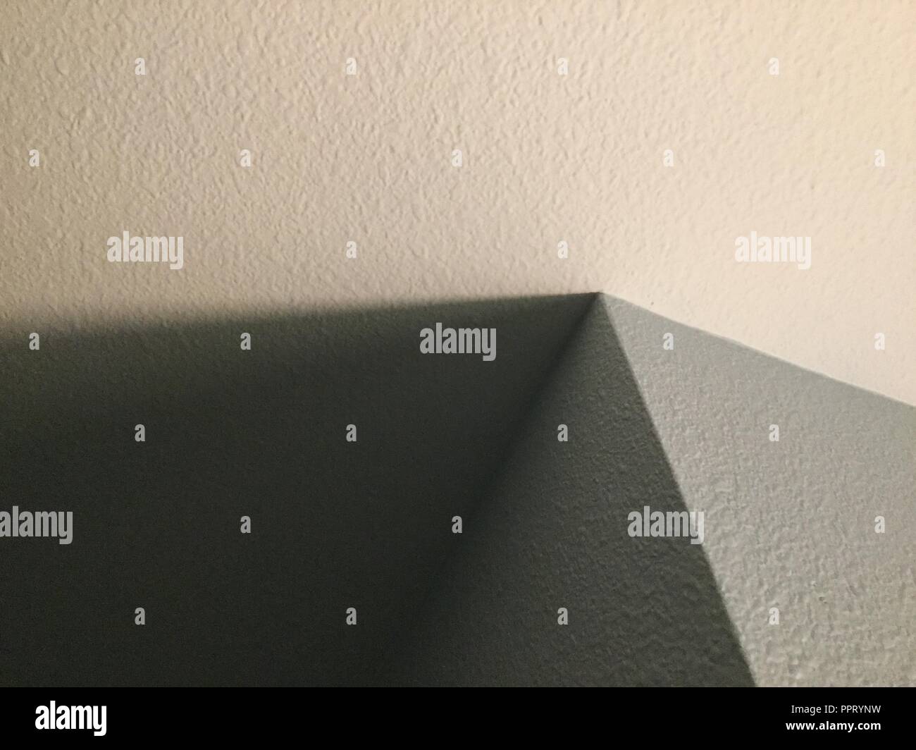 Abstract view with shadow and light of a ceiling and an outside wall ...