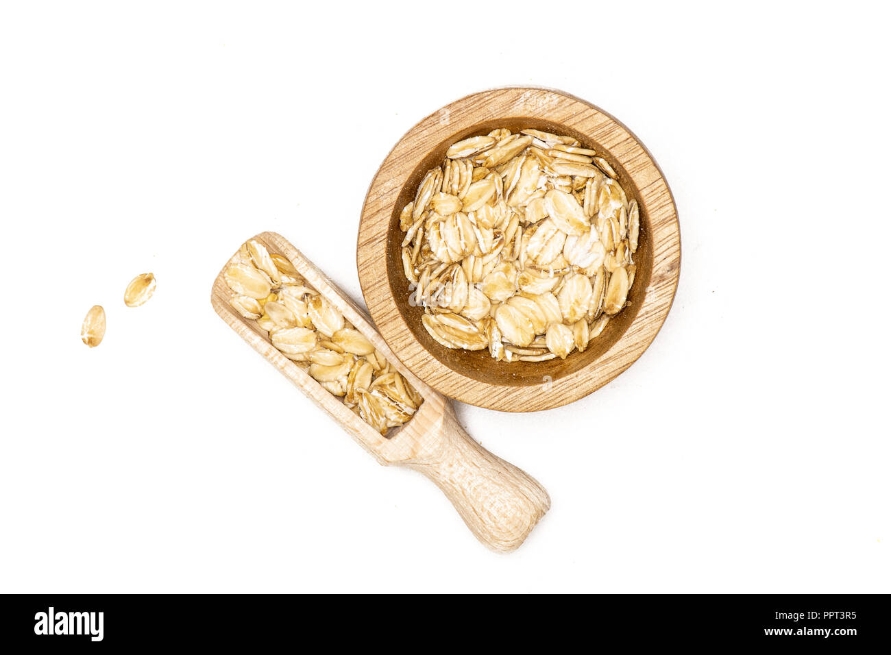 Lot of whole flat raw rolled oats in a scoop with wooden bowl flatlay ...