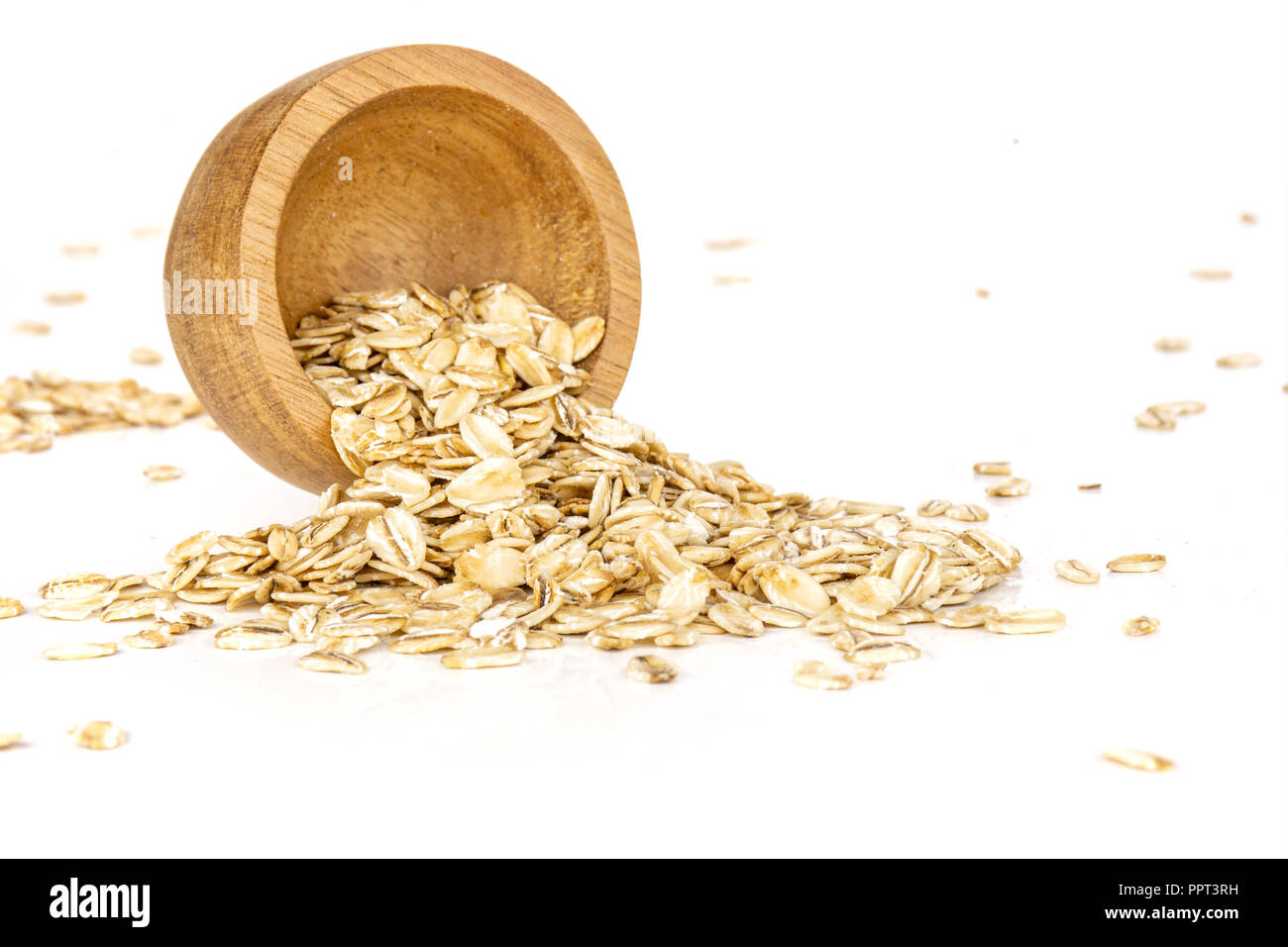 Lot of whole pouring flat raw rolled oats with wooden bowl isolated on ...