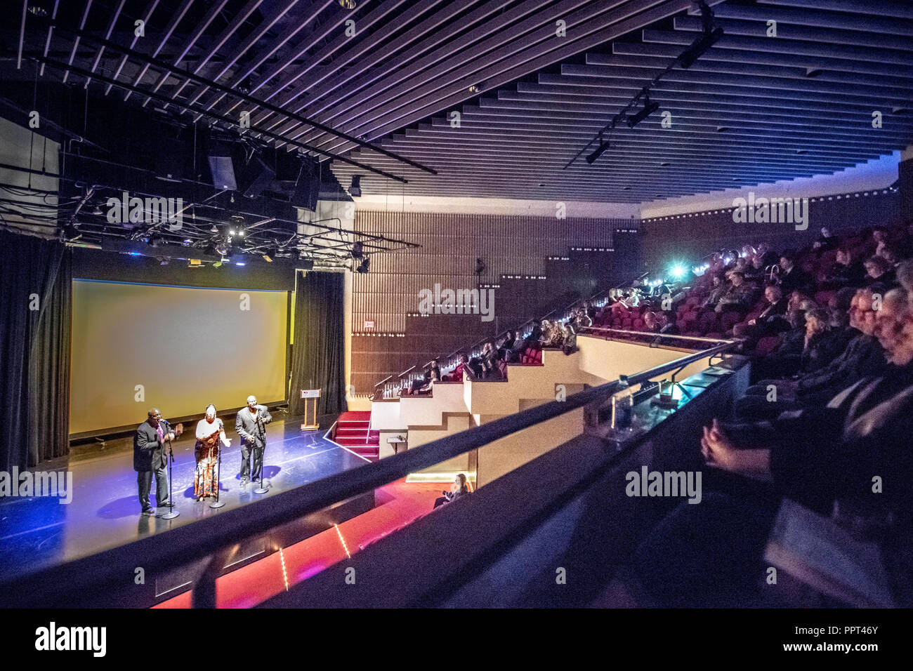 Three artist perform on stage while an audience watches Stock Photo - Alamy