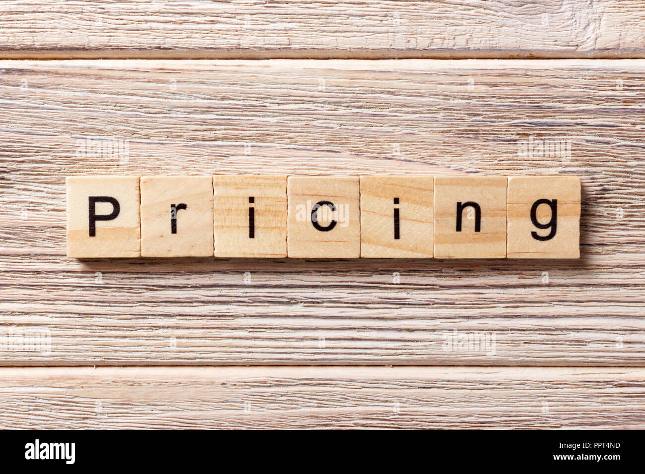 Pricing word written on wood block. Pricing text on table, concept ...